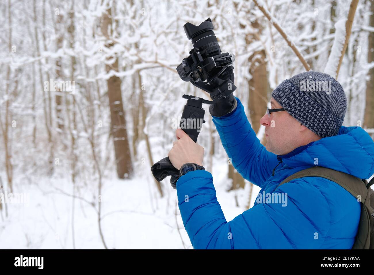 professional cameraman with camera taking shoots in snow forest Stock ...