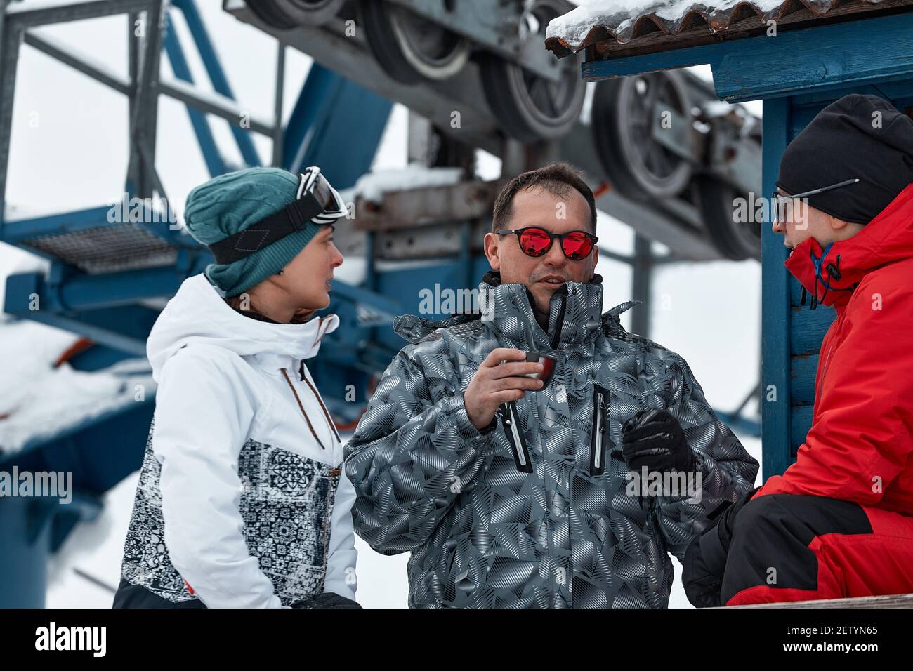 group of skiers friends on the mountain are resting and drinking coffee ...