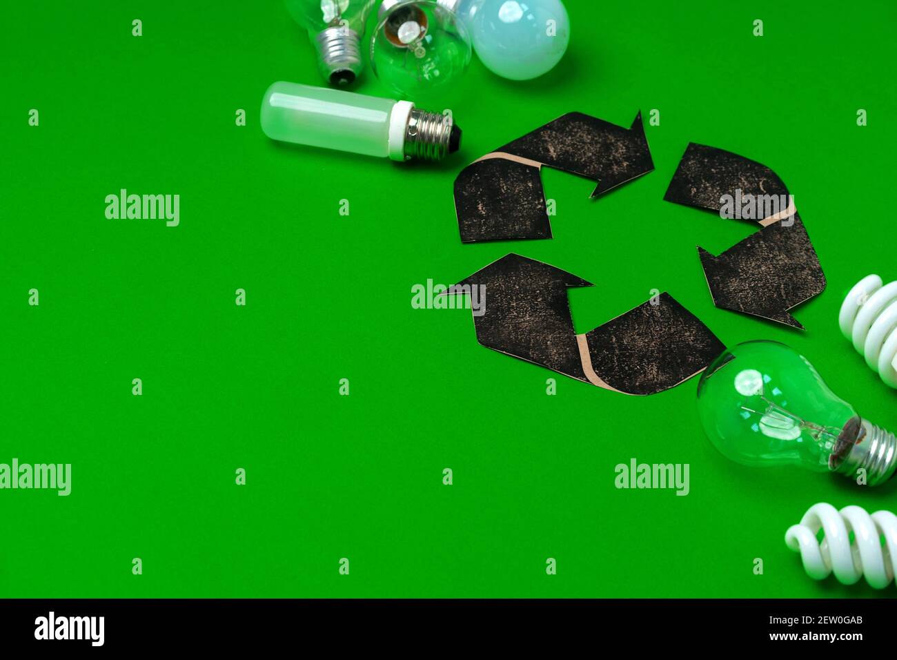 Light bulb and recycling sign on green background Stock Photo - Alamy