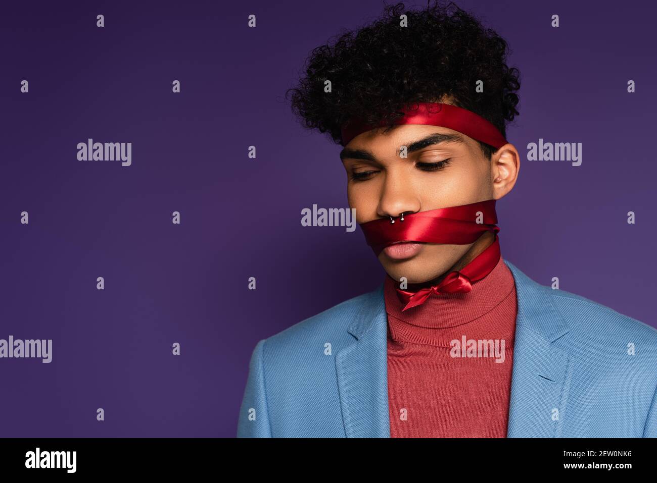 young african american man tied with red ribbon on purple Stock Photo ...