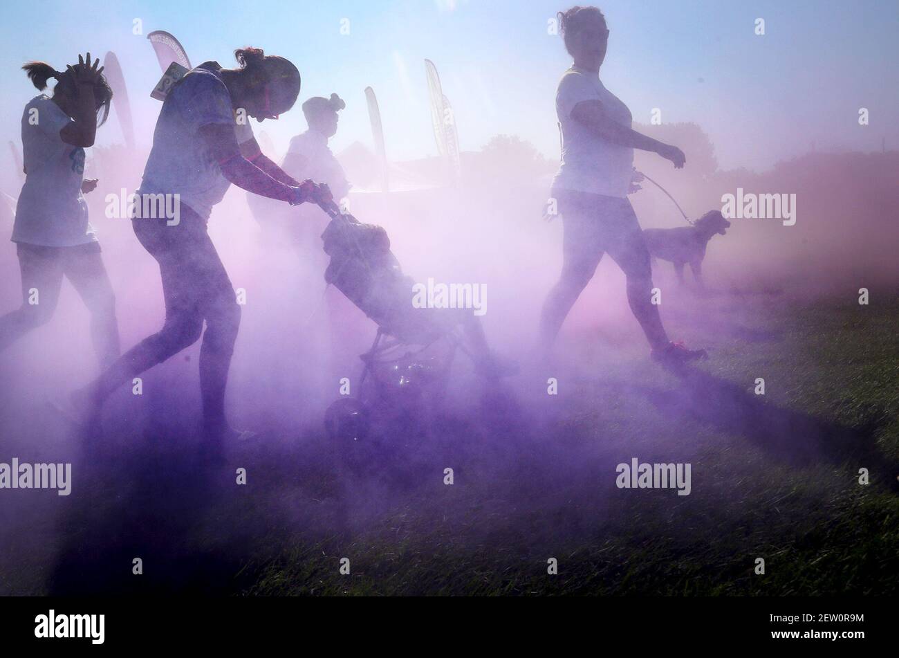 Runners pass through leaf blowers blasting color during the Color Vibe ...