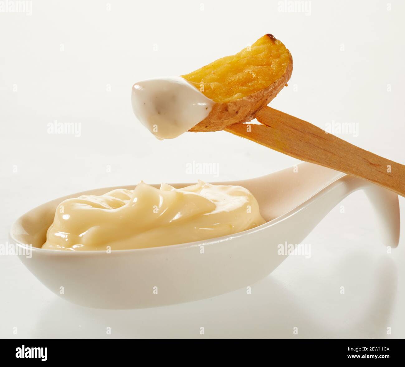 Palatable baked potato slice with peel on organic fork above ceramic ...