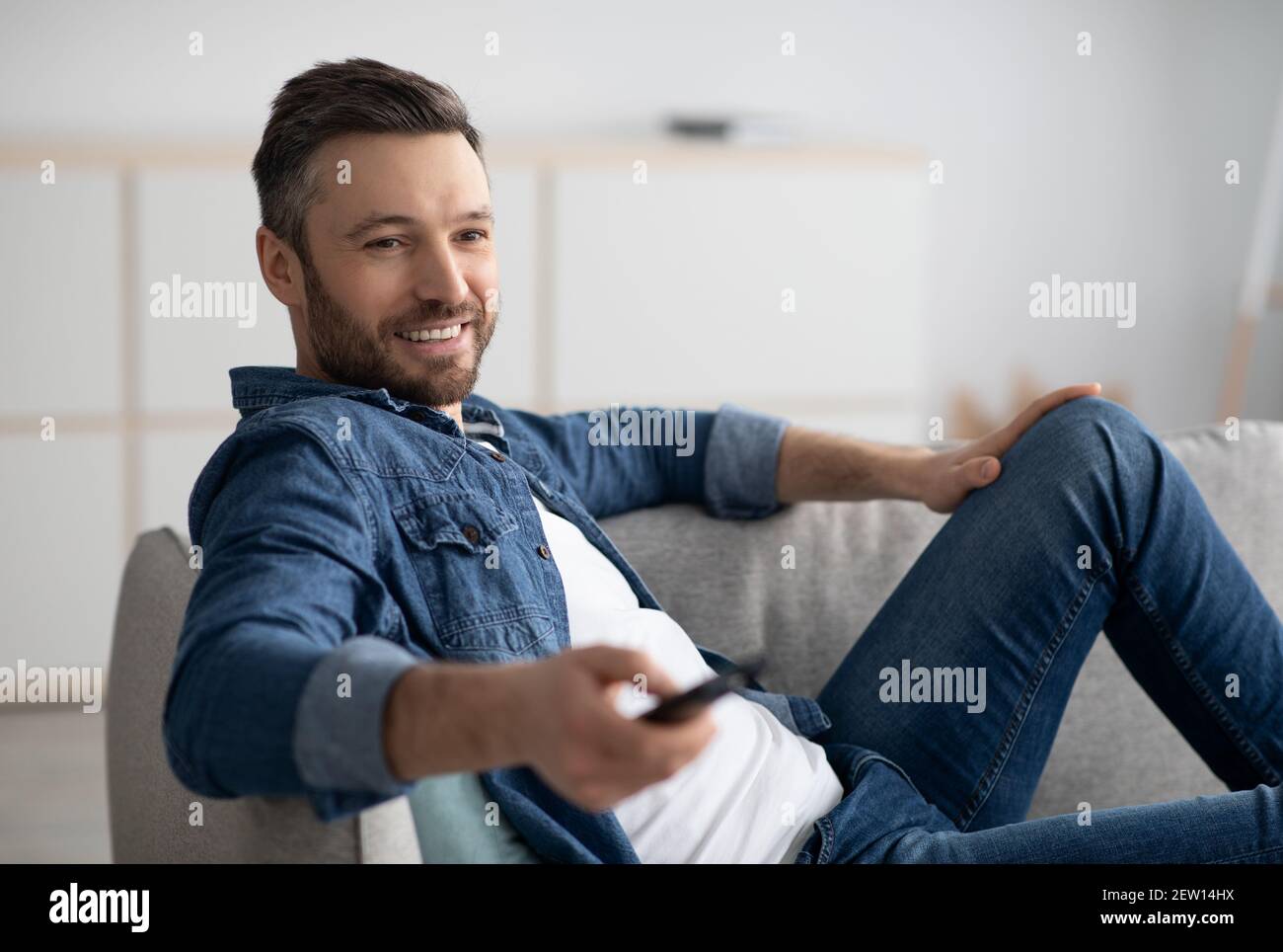 Happy man watching TV at home, copy space Stock Photo - Alamy