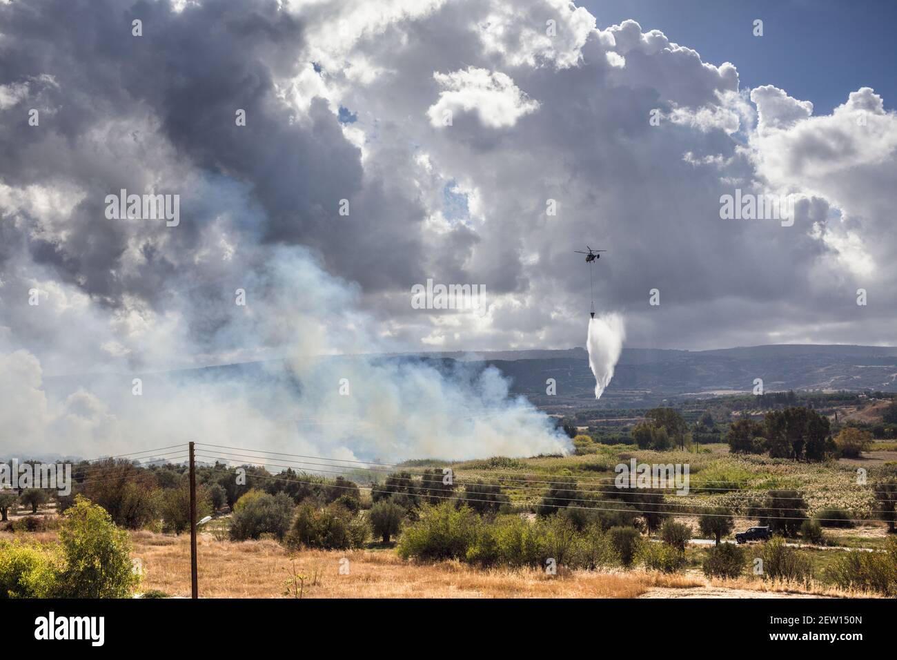 Firefighter helicopter transporting water to dump on a burning ...