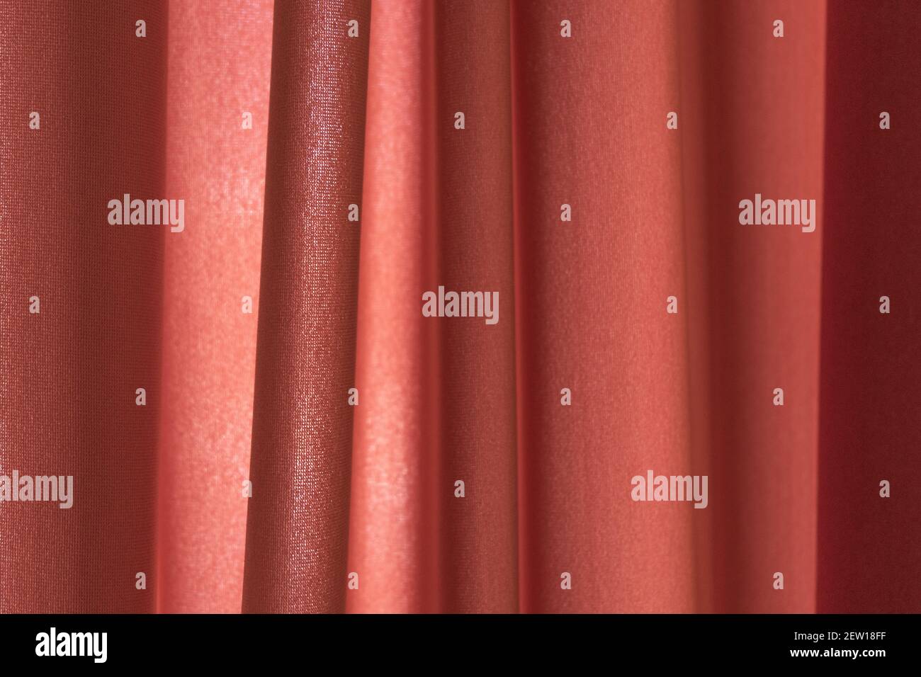 Bright red curtain decoration with vertical pleats. Smooth folds of ...