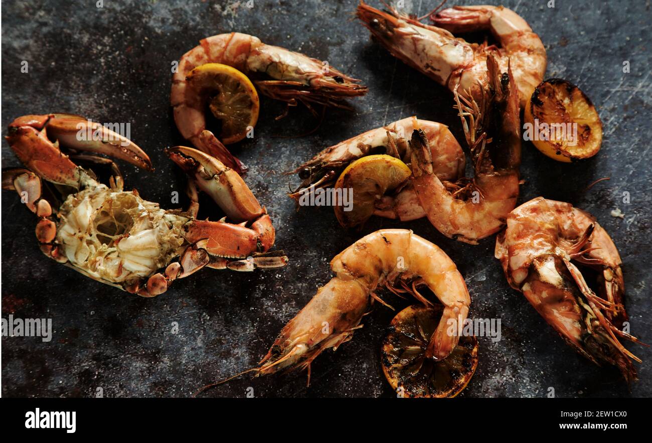 Overhead view of delectable seafood of whole prawns near crab and cut ...