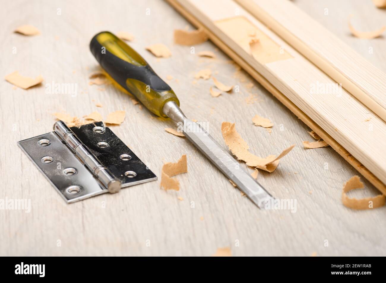 Installing the door hinge on the door frame with a hand tool at home ...