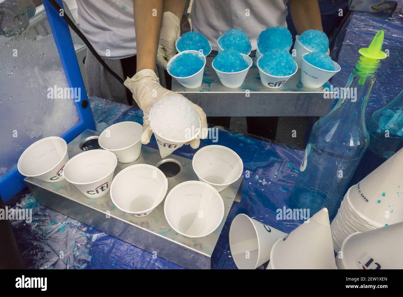 Workers prepare "Citicorp blue" snow cones to distribute as part of ...