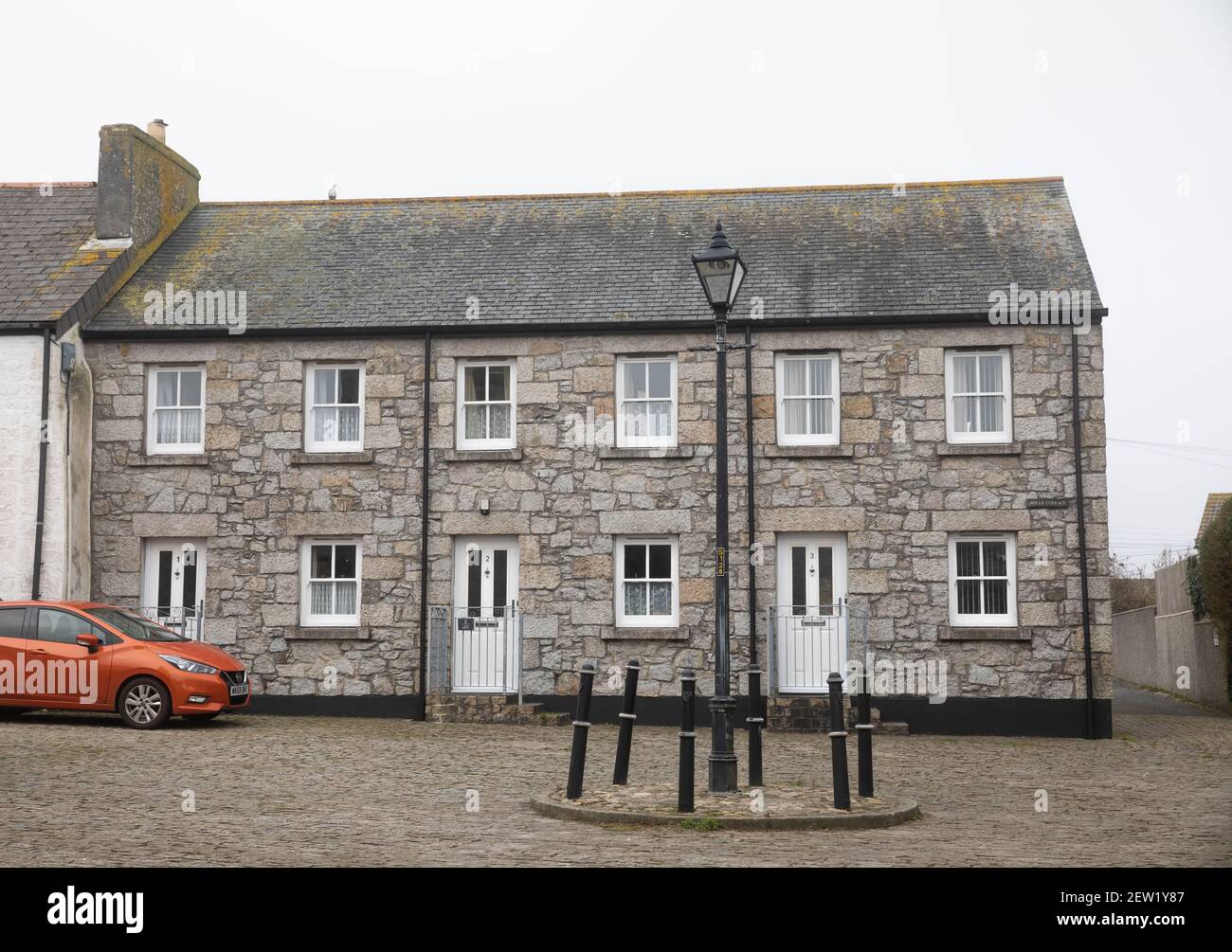A row of stone clad houses in St Day, Cornwall with a small roundabout ...