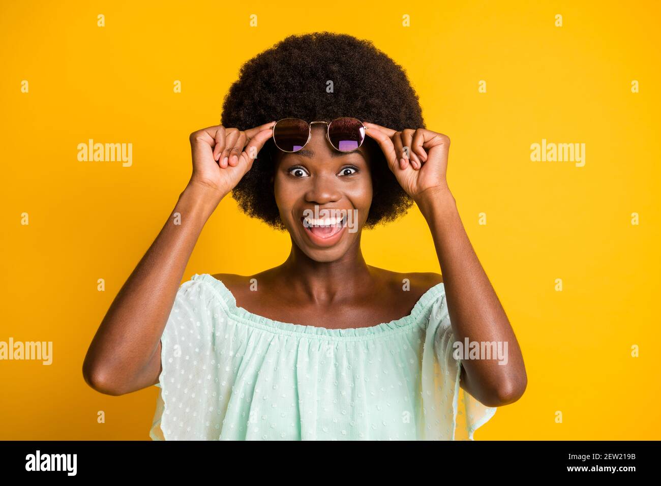 Photo portrait of excited girl lifting up glasses isolated on vivid ...