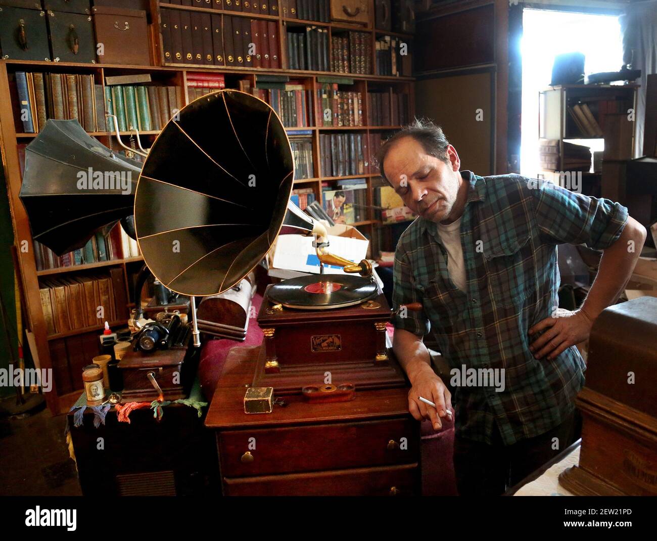 Vintage Music owner Scott Holthus closes his eyes while listening to a ...