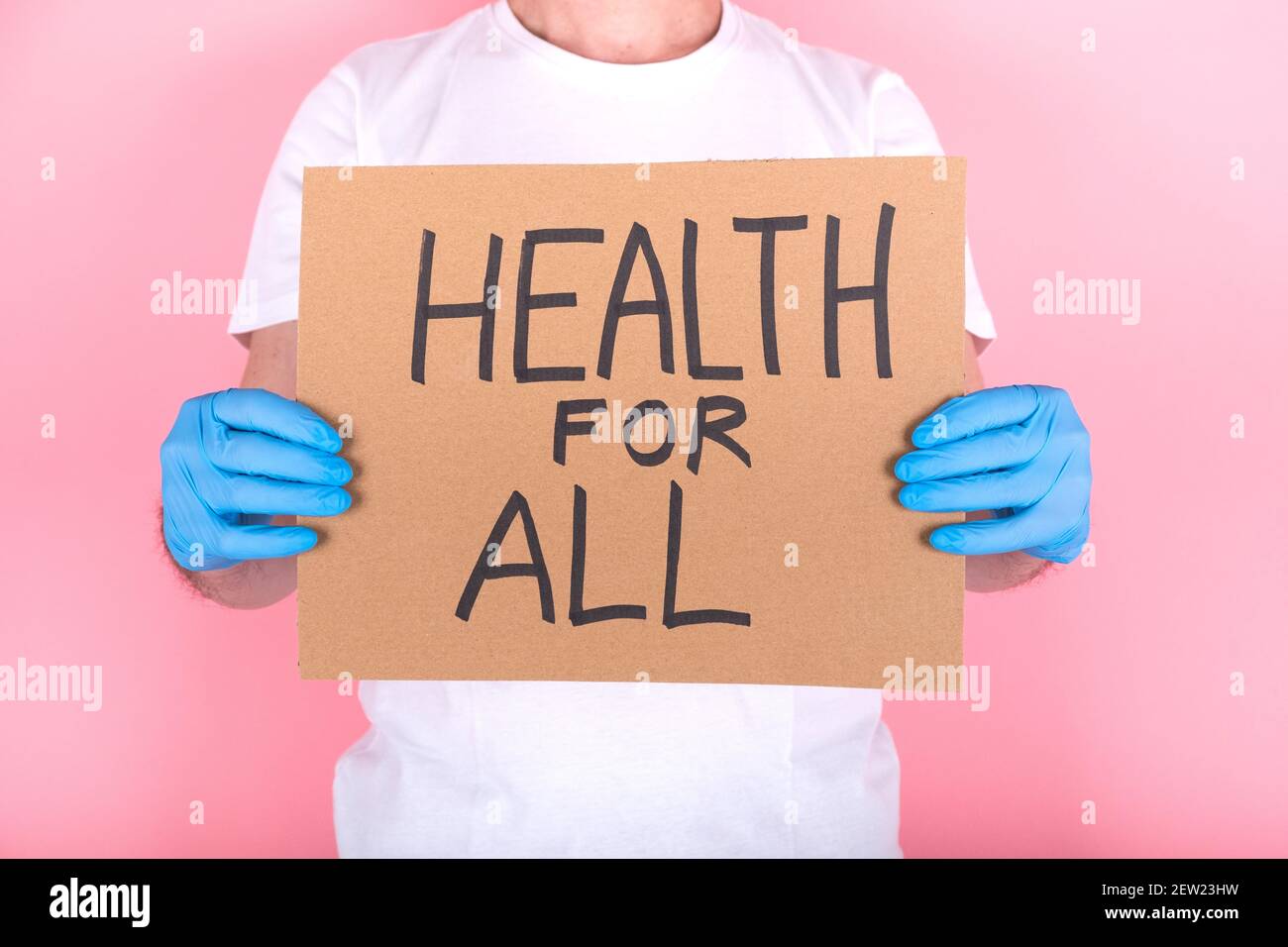 cardboard with the message HEALTH FOR ALL. Anonymous hands protected by ...
