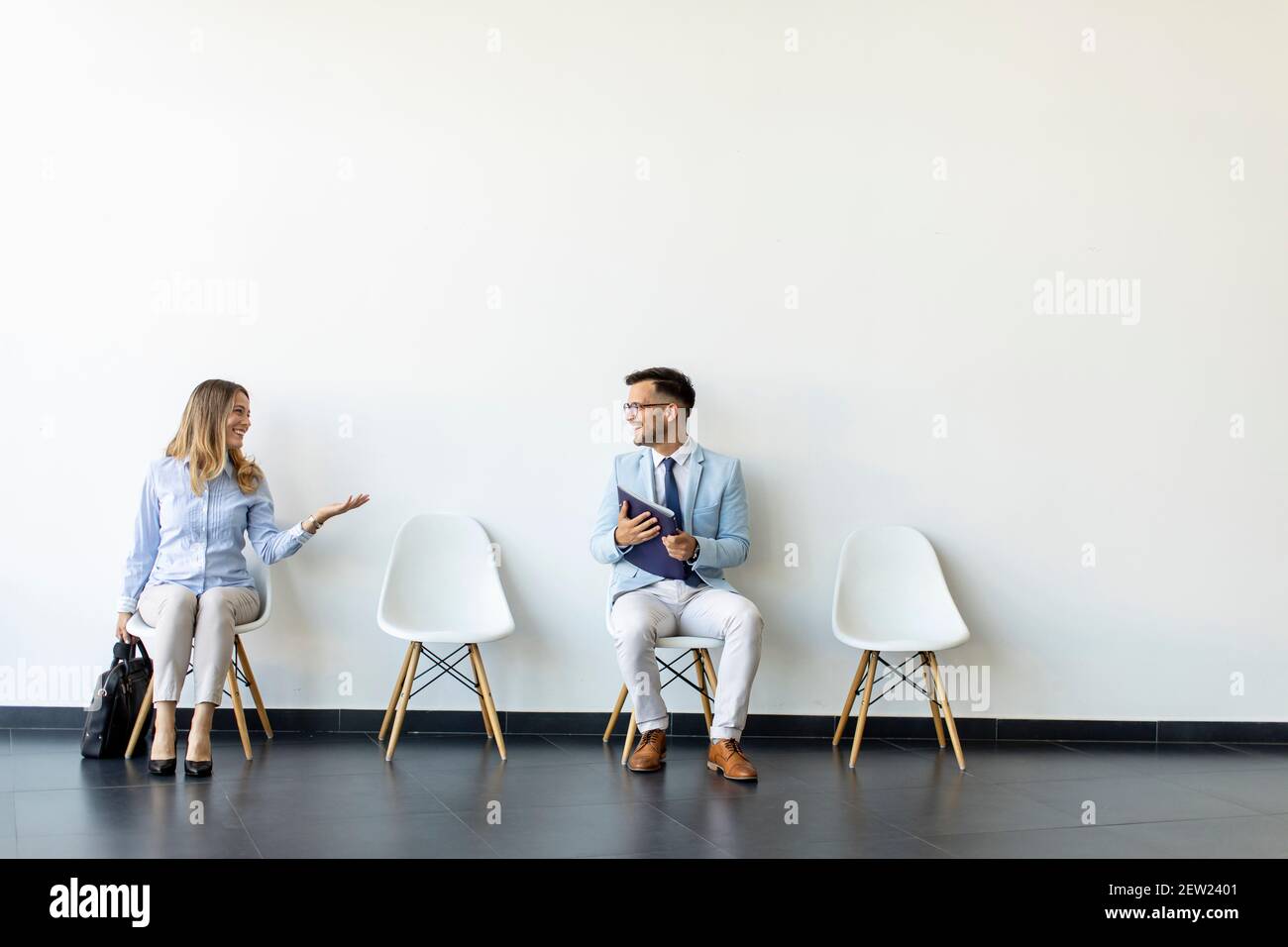Young people sitting at chairs in the waiting room before an interview ...