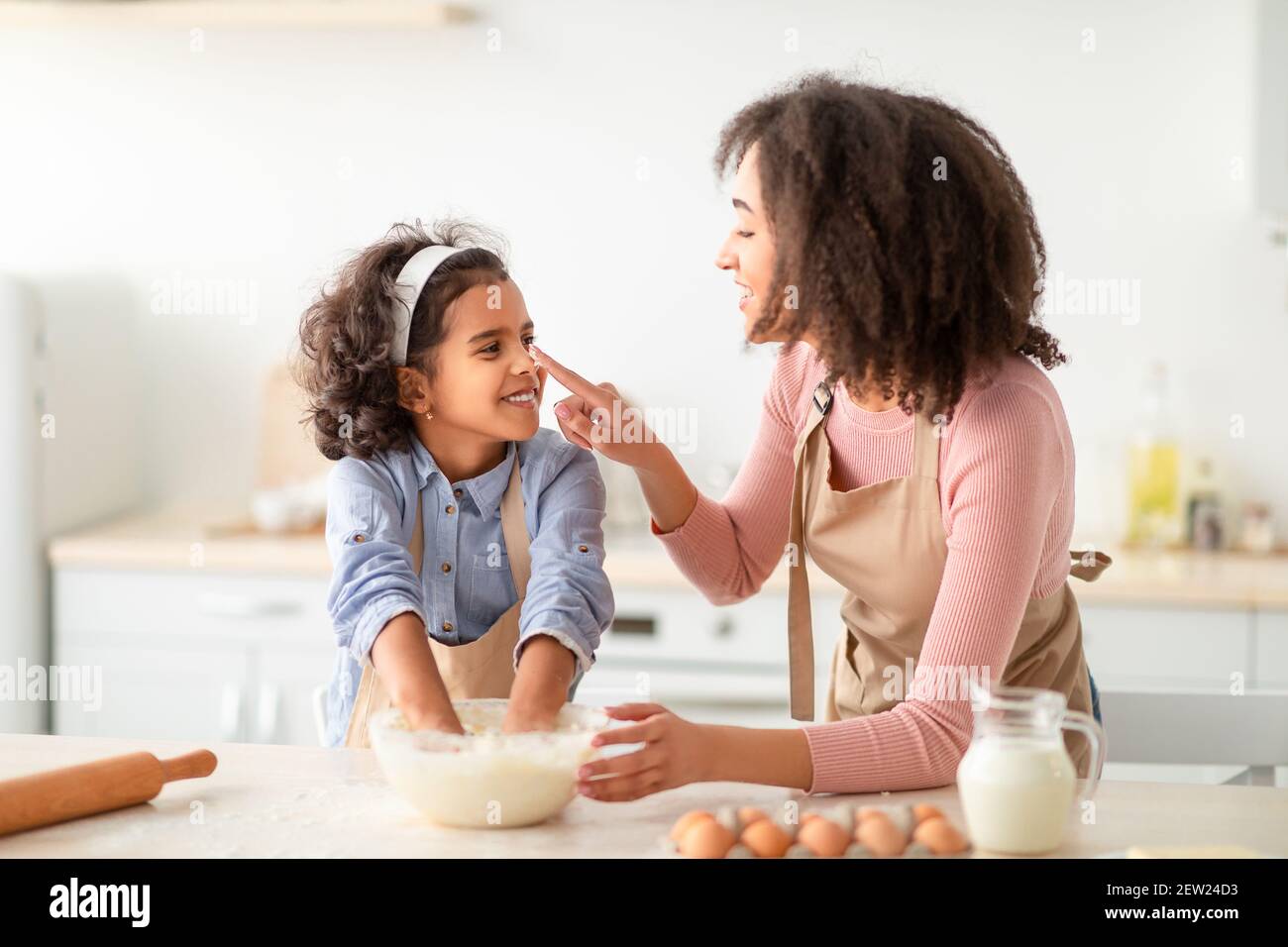Black woman and his daughter cooking and playing with flour Stock Photo ...