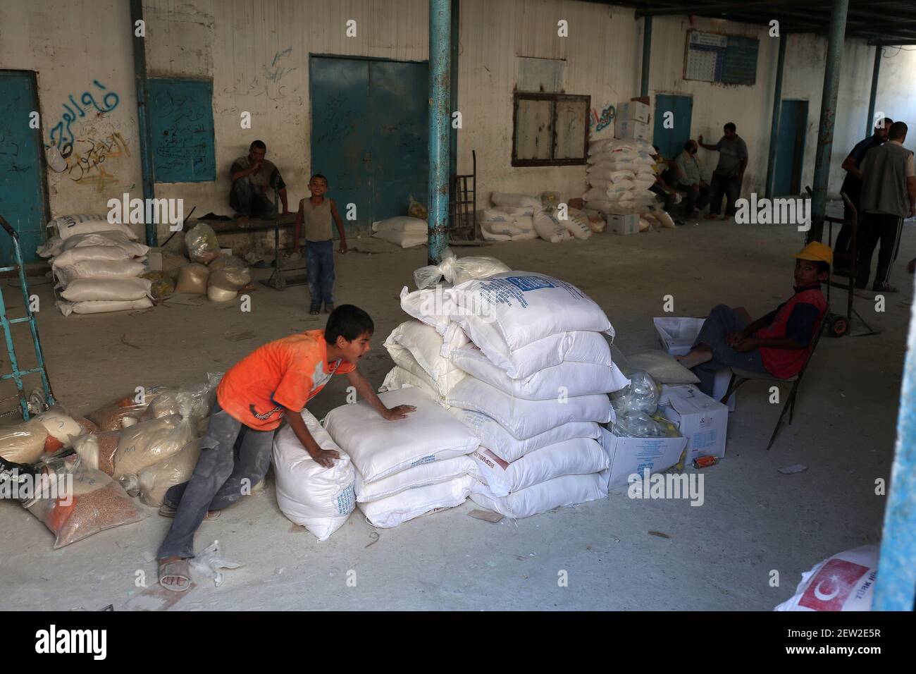 Palestinians receive their monthly food aid at a United Nations ...