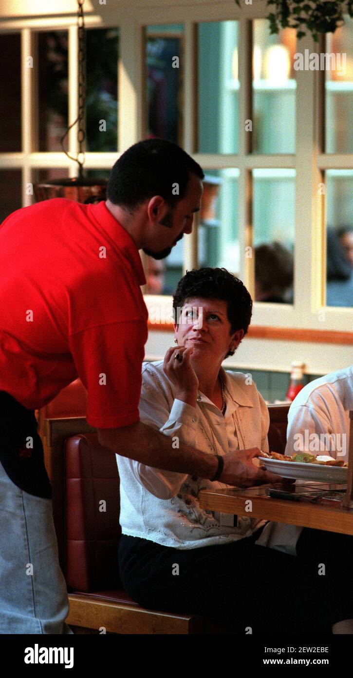 A restaurant waiter clears his customers table June 1998 Stock Photo ...
