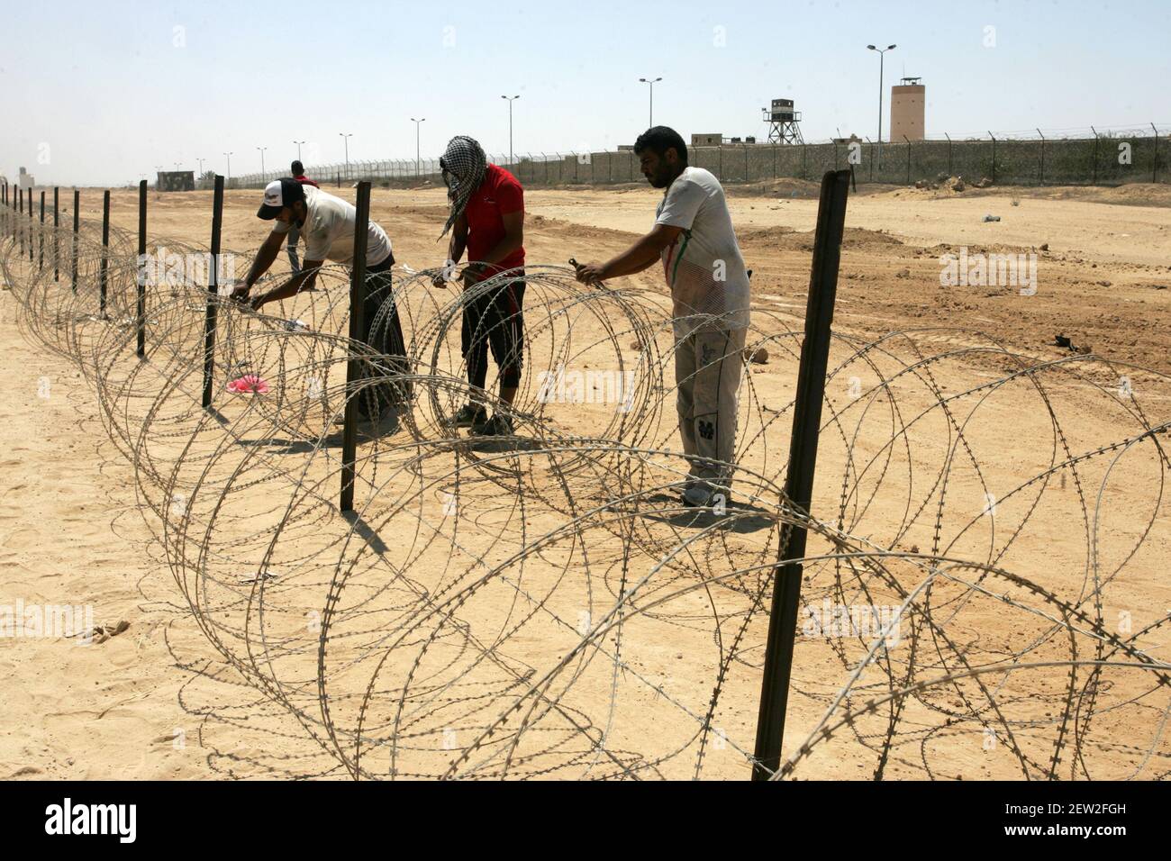Palestinian workers install barbed wire along the border with Egypt ...