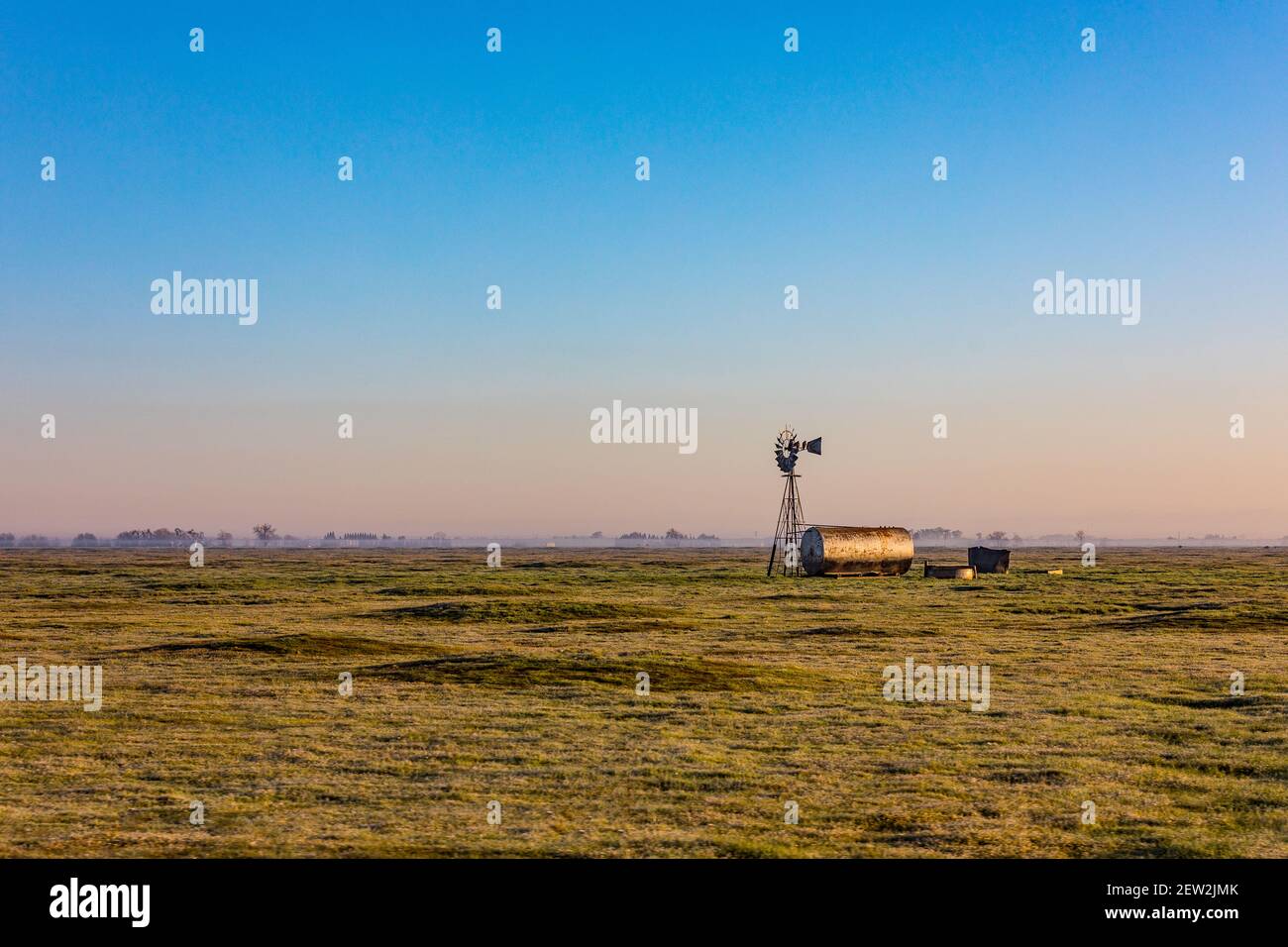 A Windmill and water tank in a pasture in Merced County Central Valley ...