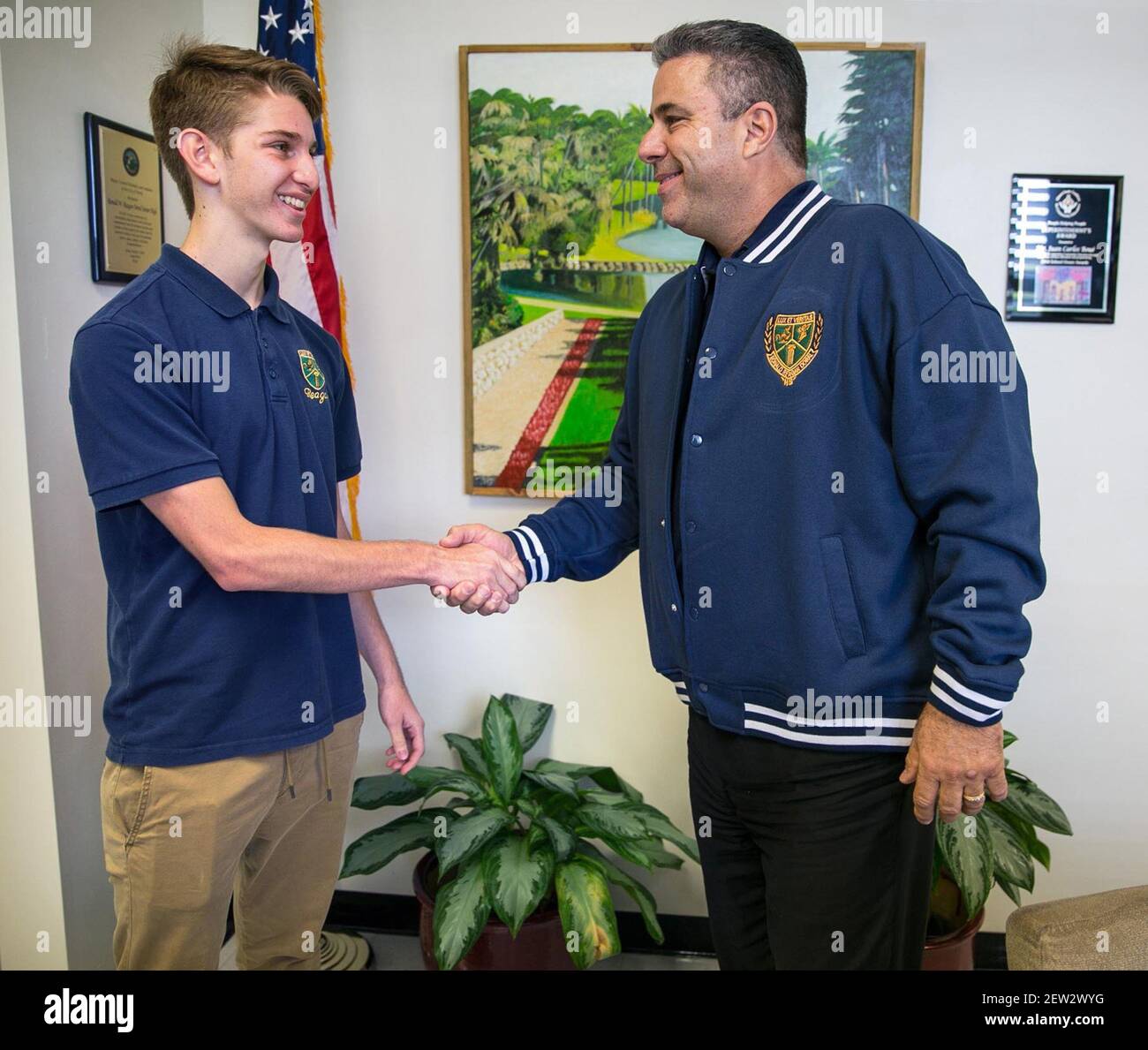Ronald W. Reagan Doral High School principal Juan Carlos Boue, right, shakes hand with Antonio ...