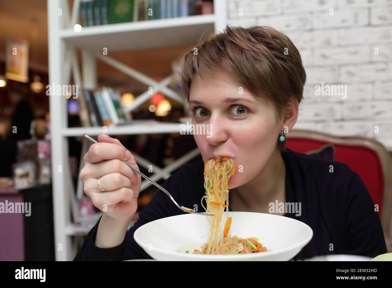The woman eating noodles in the restaurant Stock Photo - Alamy