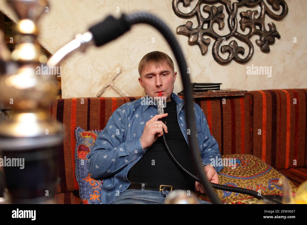 Man smoking shisha in the asian restaurant Stock Photo - Alamy