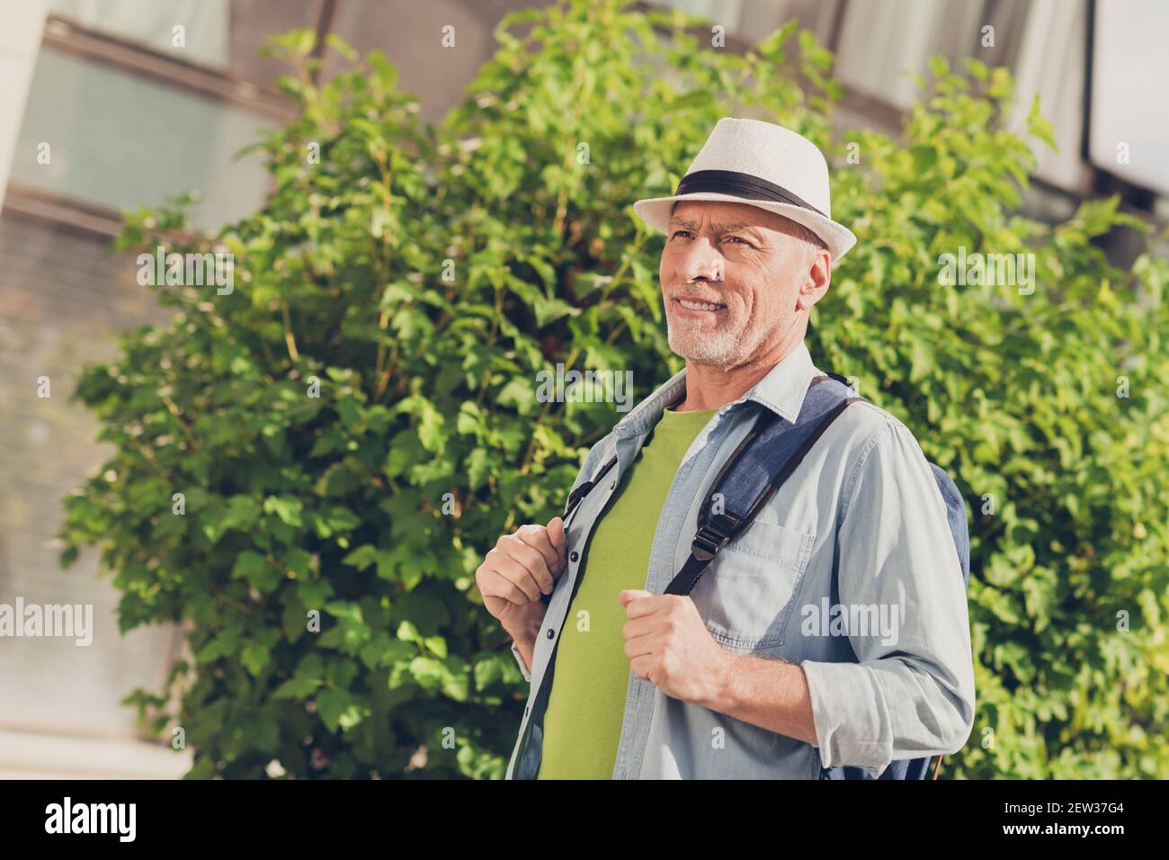 Photo of sweet attractive age guy wear denim shirt arm cap walking ...