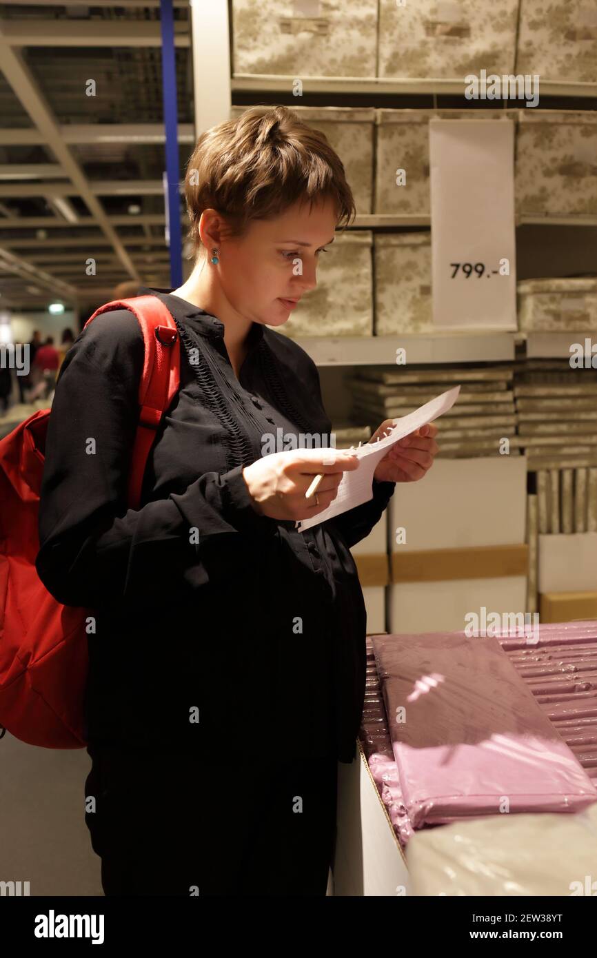 Woman reading shopping list in the store Stock Photo - Alamy