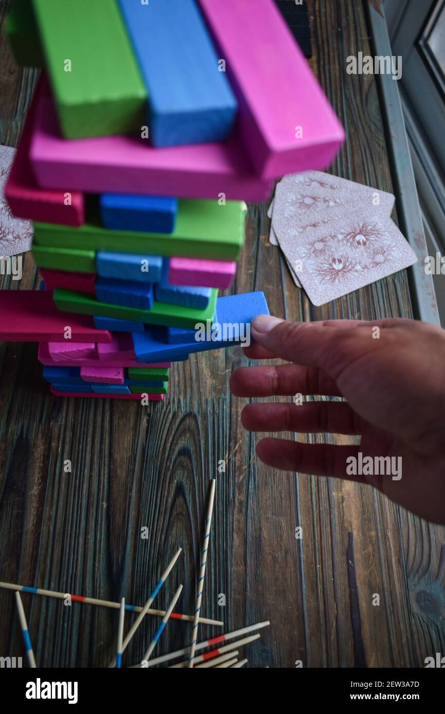 Top view of a hand pulling out a blue brick of Jenga game - table games ...