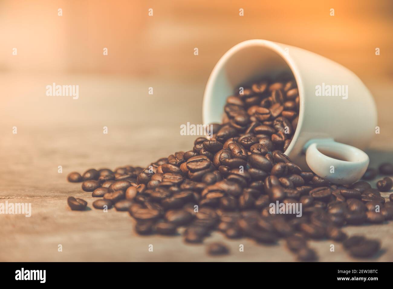 The coffee beans in the cups on the old wooden boards are presented in ...