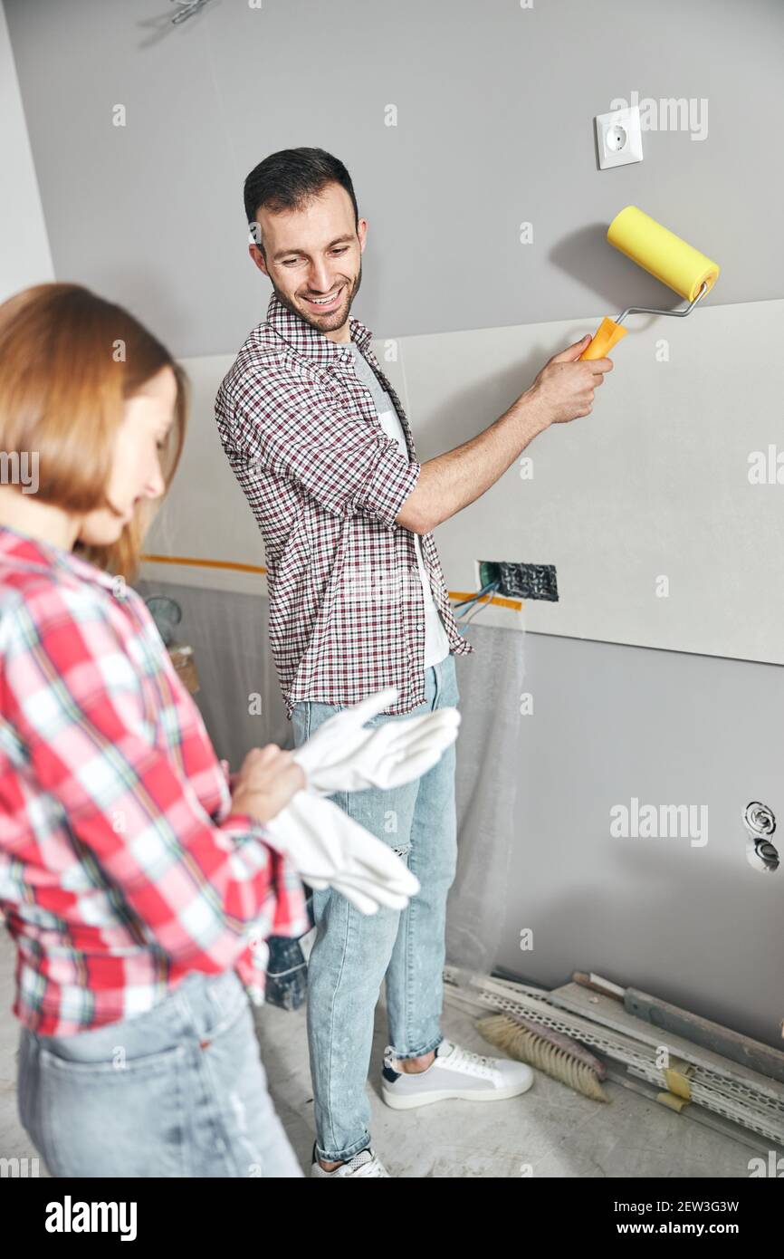 Woman worker assisting in painting the wall Stock Photo - Alamy