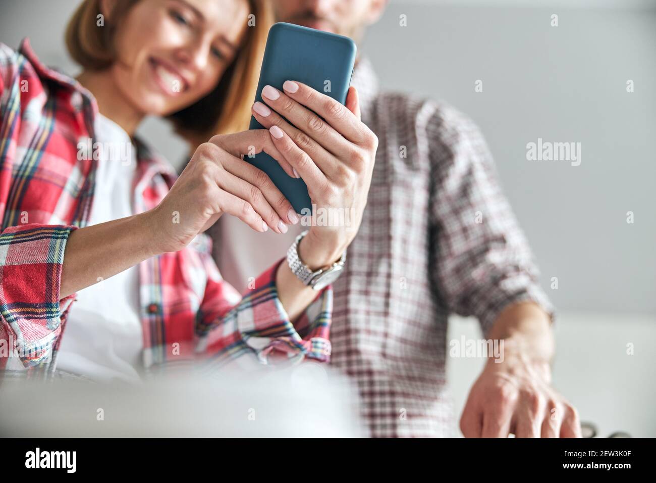 Merry lady photographing herself and her colleague in the workplace ...
