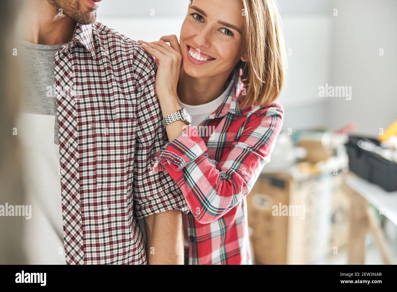 Pleased young woman and her husband posing in their new apartment Stock ...