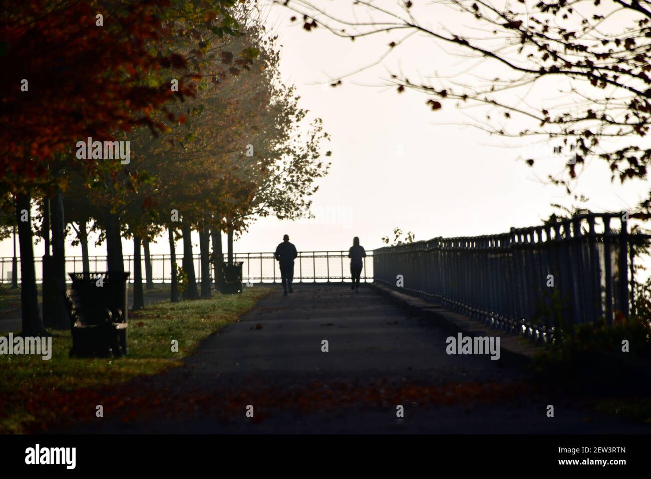 2 runners down a path along a river in a park Stock Photo - Alamy