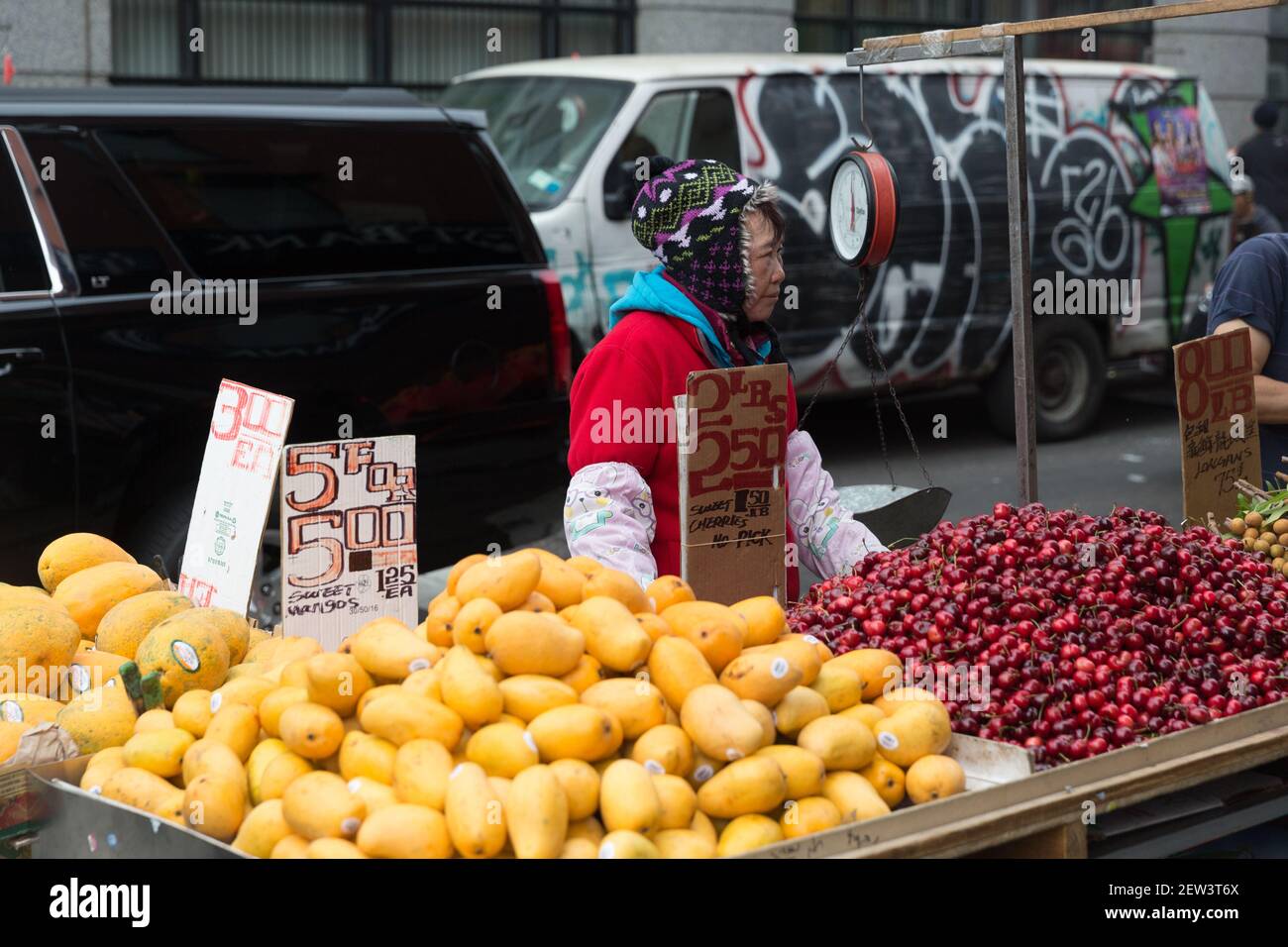 New York City, NY USA Senior woman selling cherries and mangoes at a ...