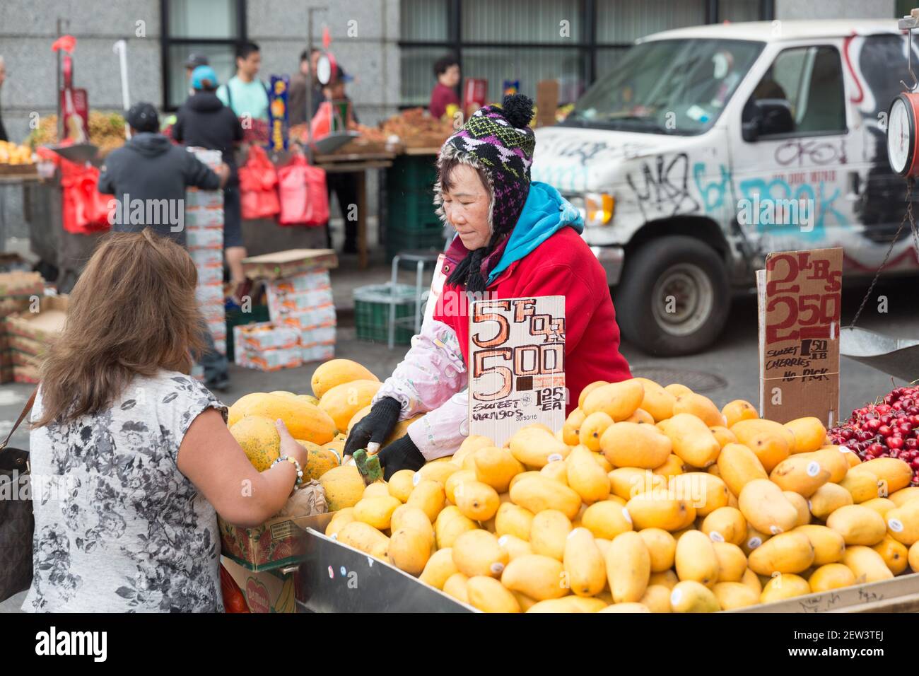 New York City, NY USA Senior woman selling cherries and mangoes at a ...