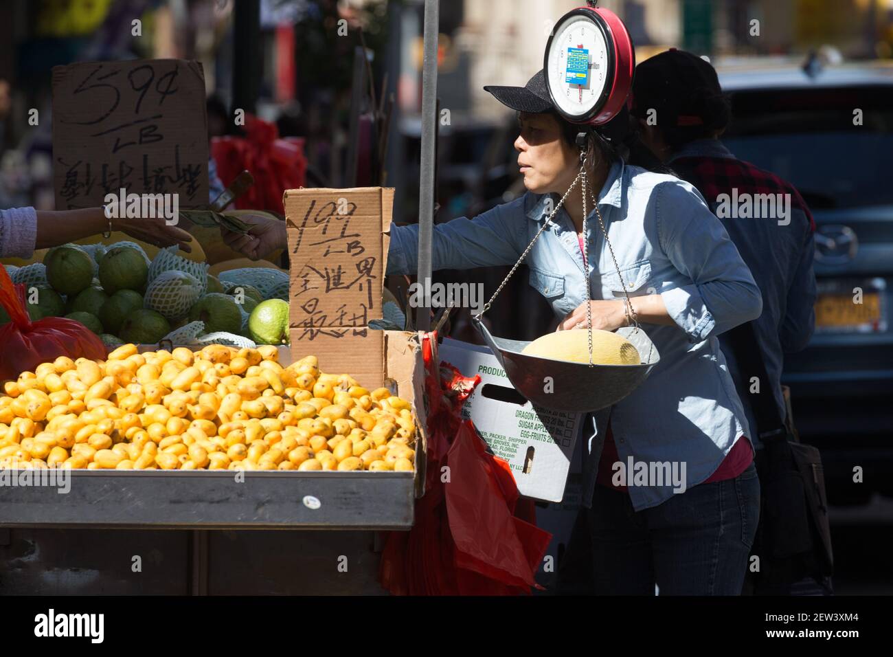 New York City, NY USA Senior woman selling mangoes at a fruit stand in ...