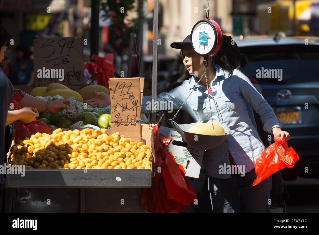 New York City, NY USA Senior woman selling mangoes at a fruit stand in ...