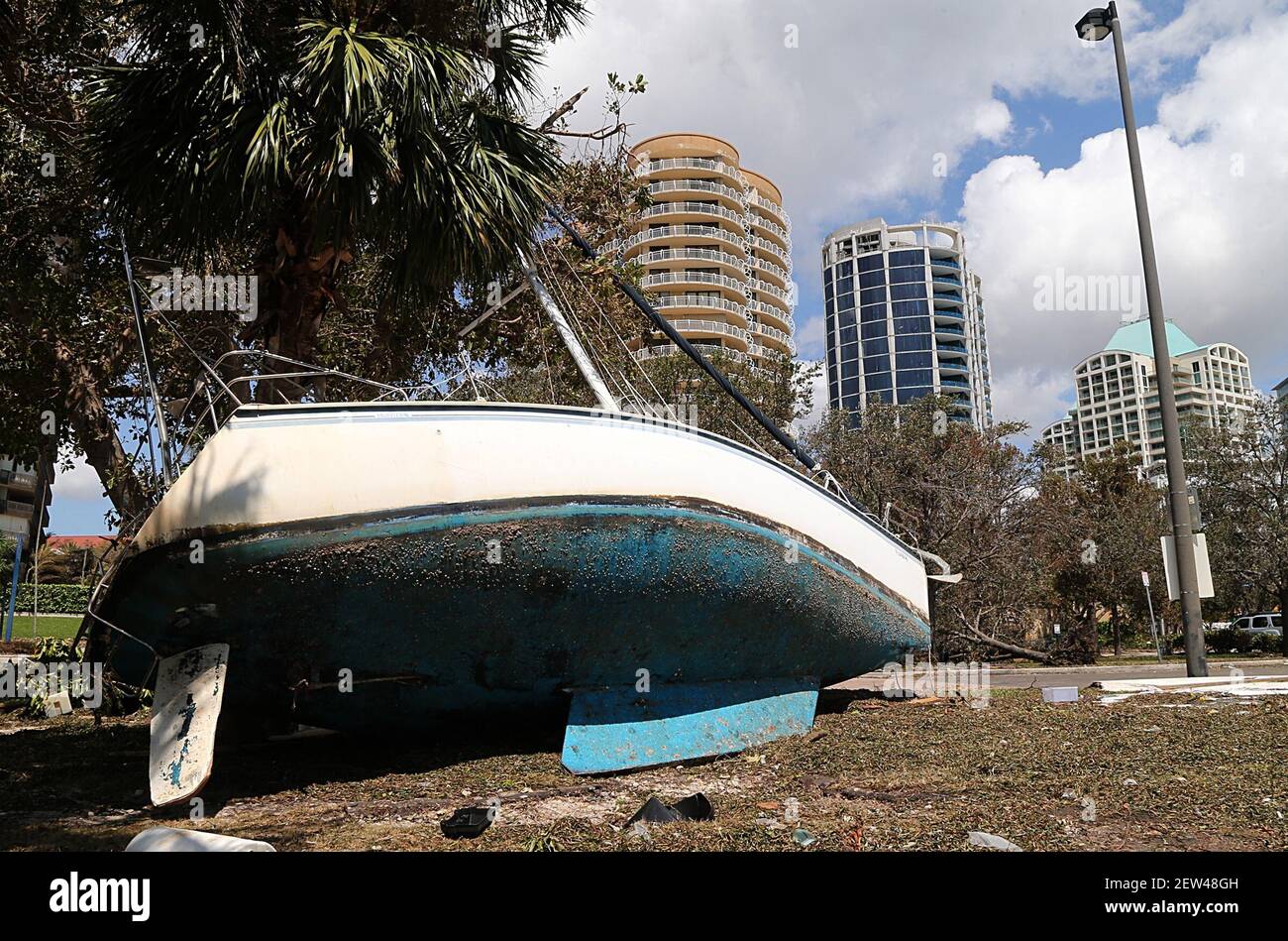 A damaged sail boat washed ashore in the Grove Key Marina parking lot ...