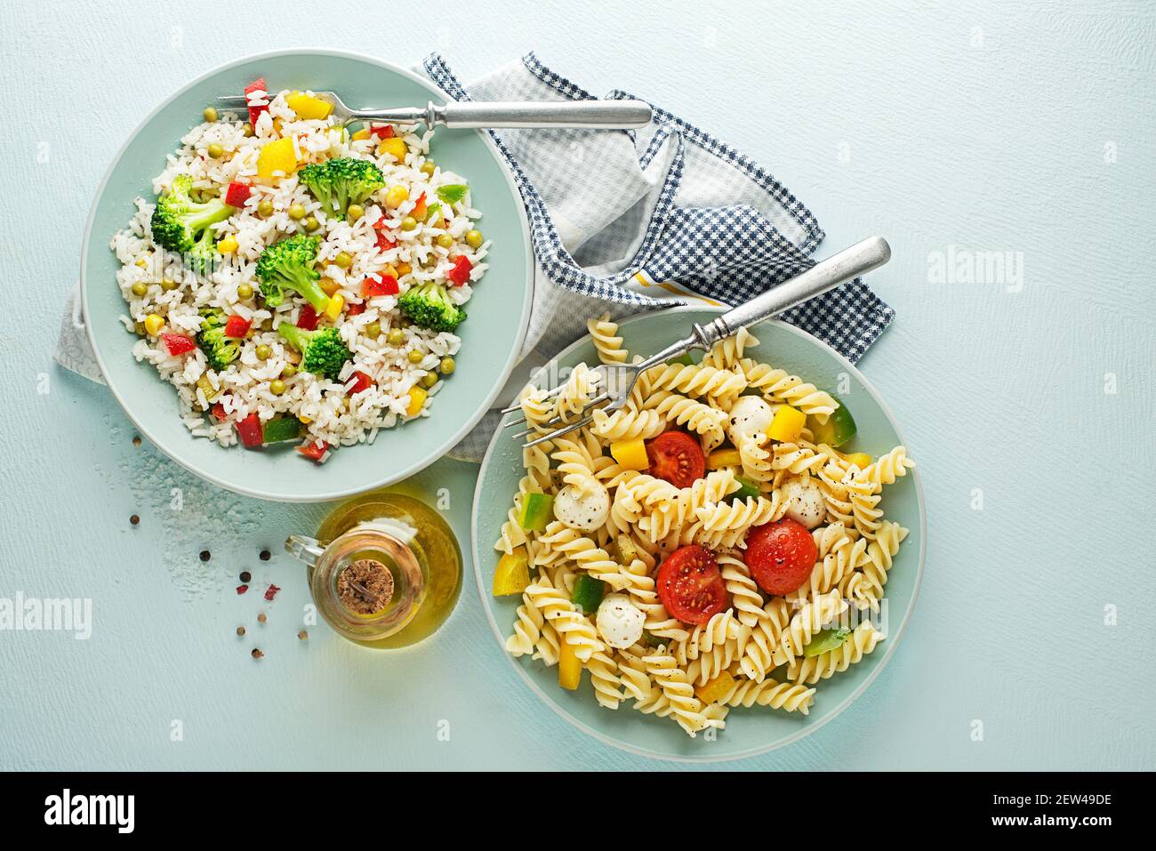 Fresh pasta salad and rice salad with mixed vegetables in plates on ...