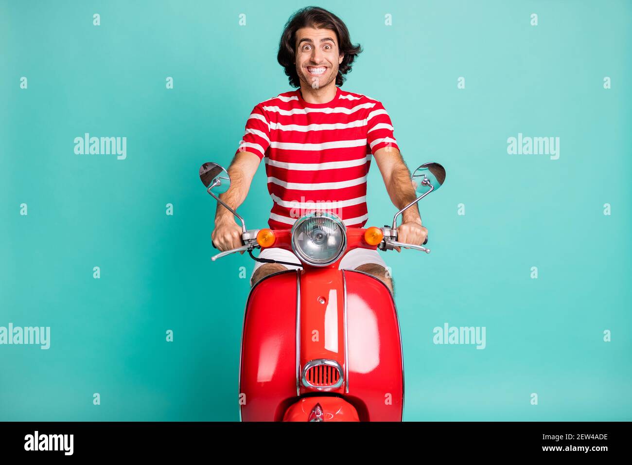 Portrait of handsome cheerful guy riding moped enjoying having fun ...