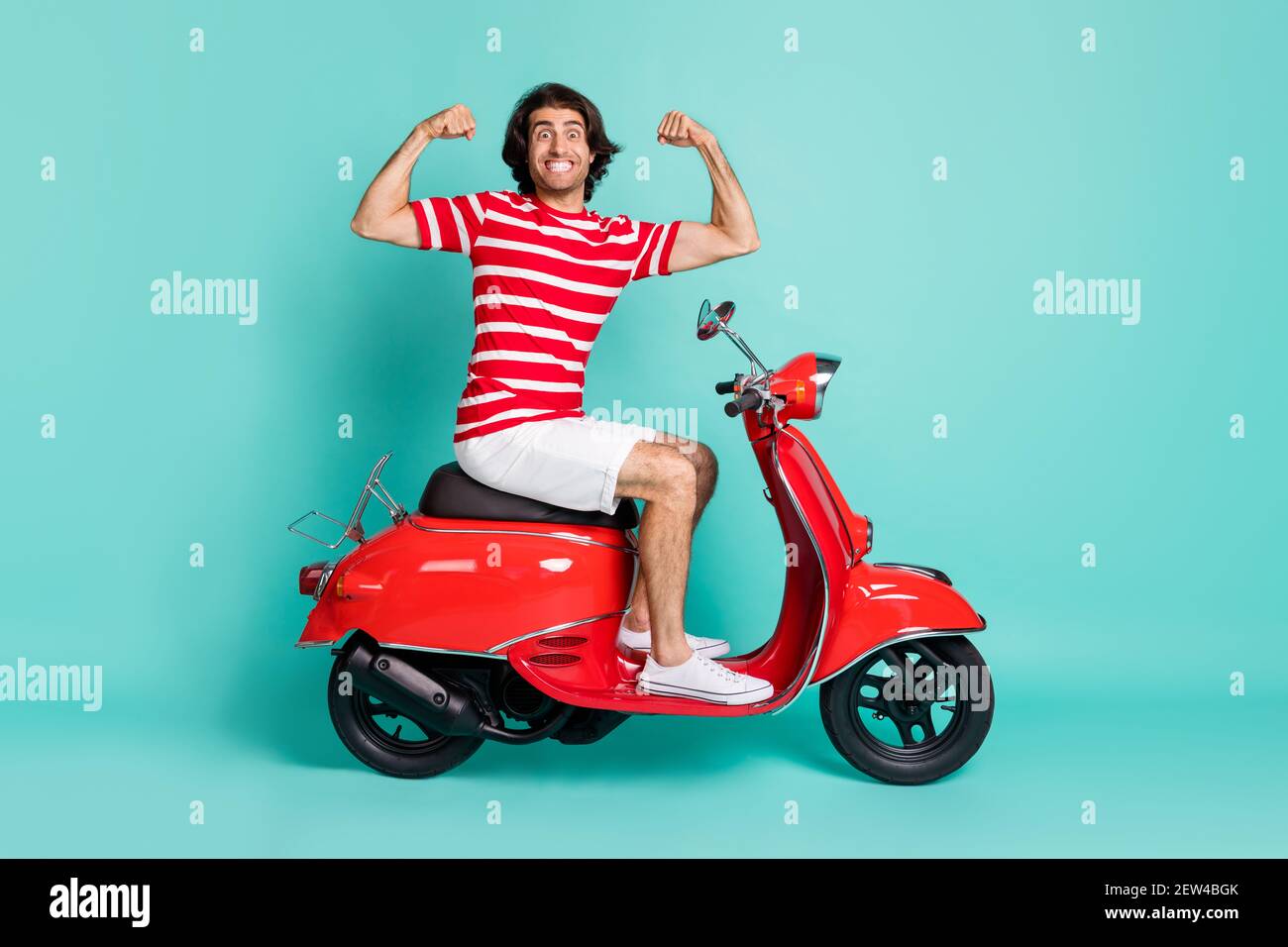 Portrait of handsome cheerful strong guy sitting on moped showing ...