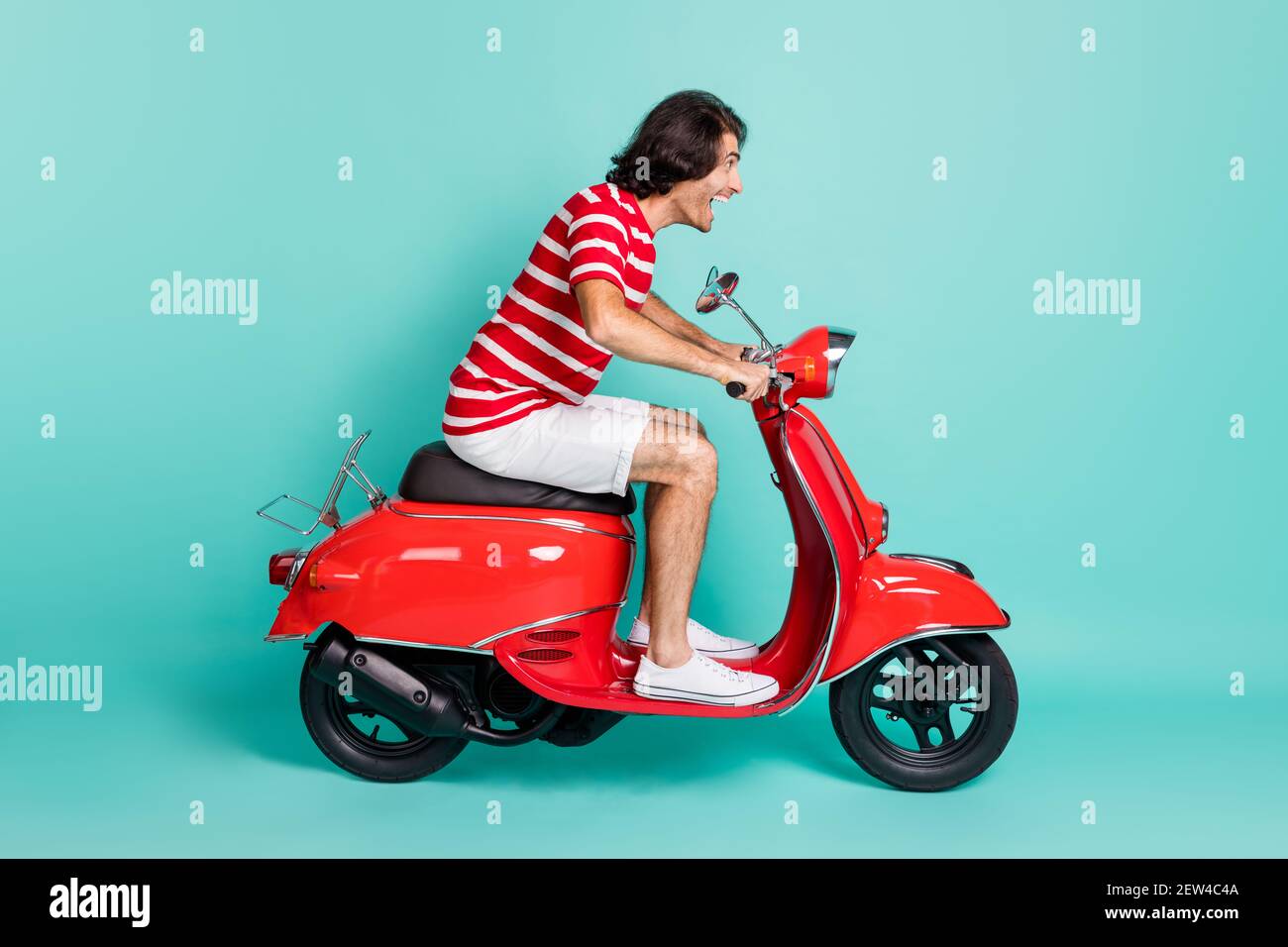 Profile side view of handsome cheerful guy driving moped having fun ...