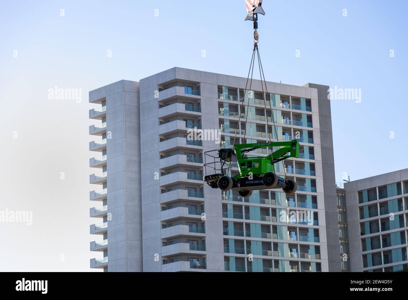 Small plant being lifted into place on a building construction site. UK ...