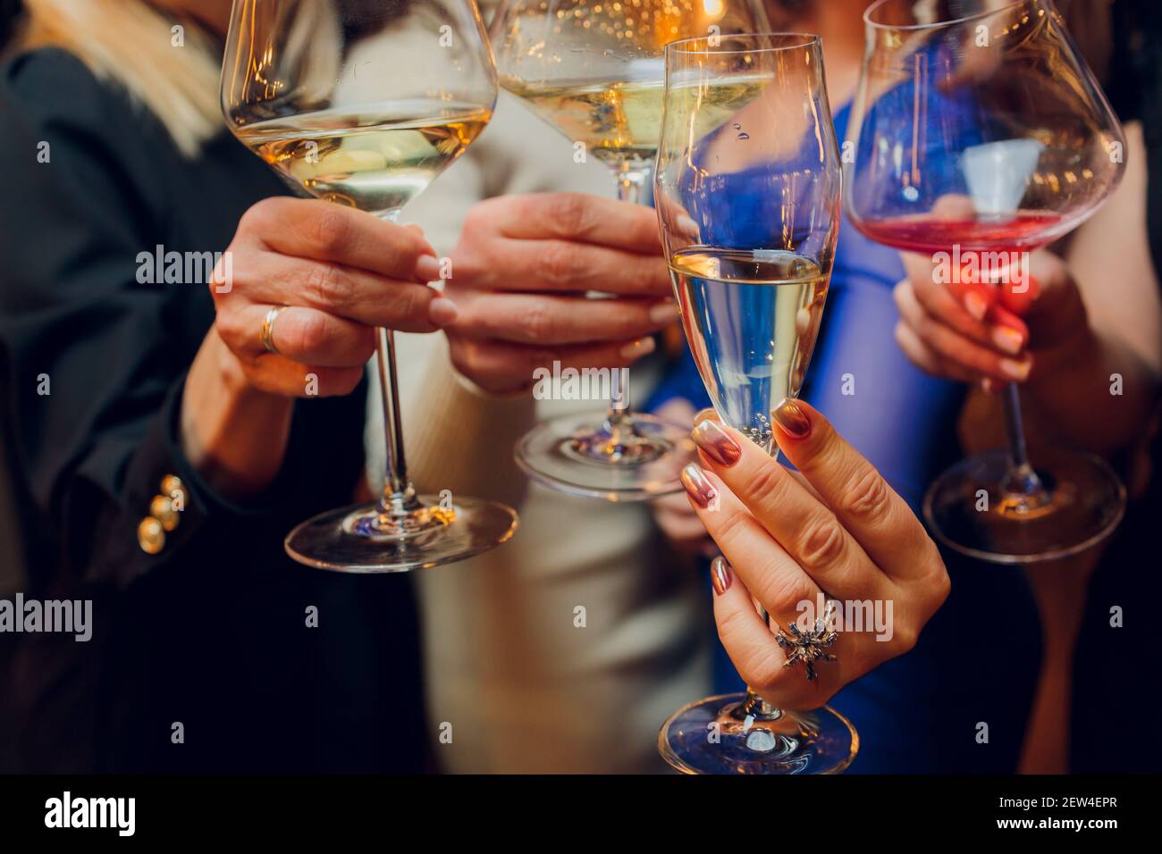 Clinking glasses with alcohol and toasting, party Stock Photo - Alamy