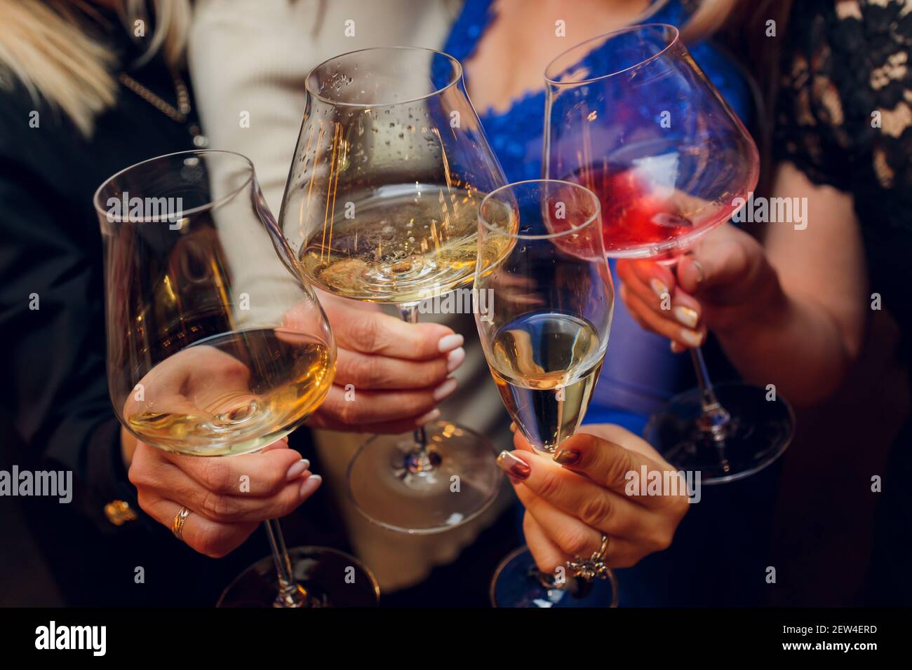 Clinking glasses with alcohol and toasting, party Stock Photo - Alamy