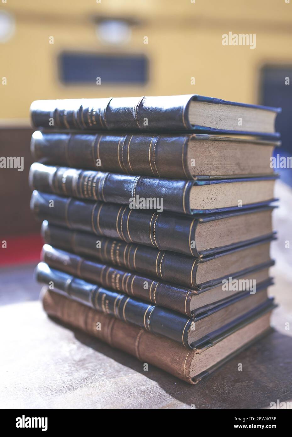 several old and slightly worn books stacked in a tower on a desk Stock ...