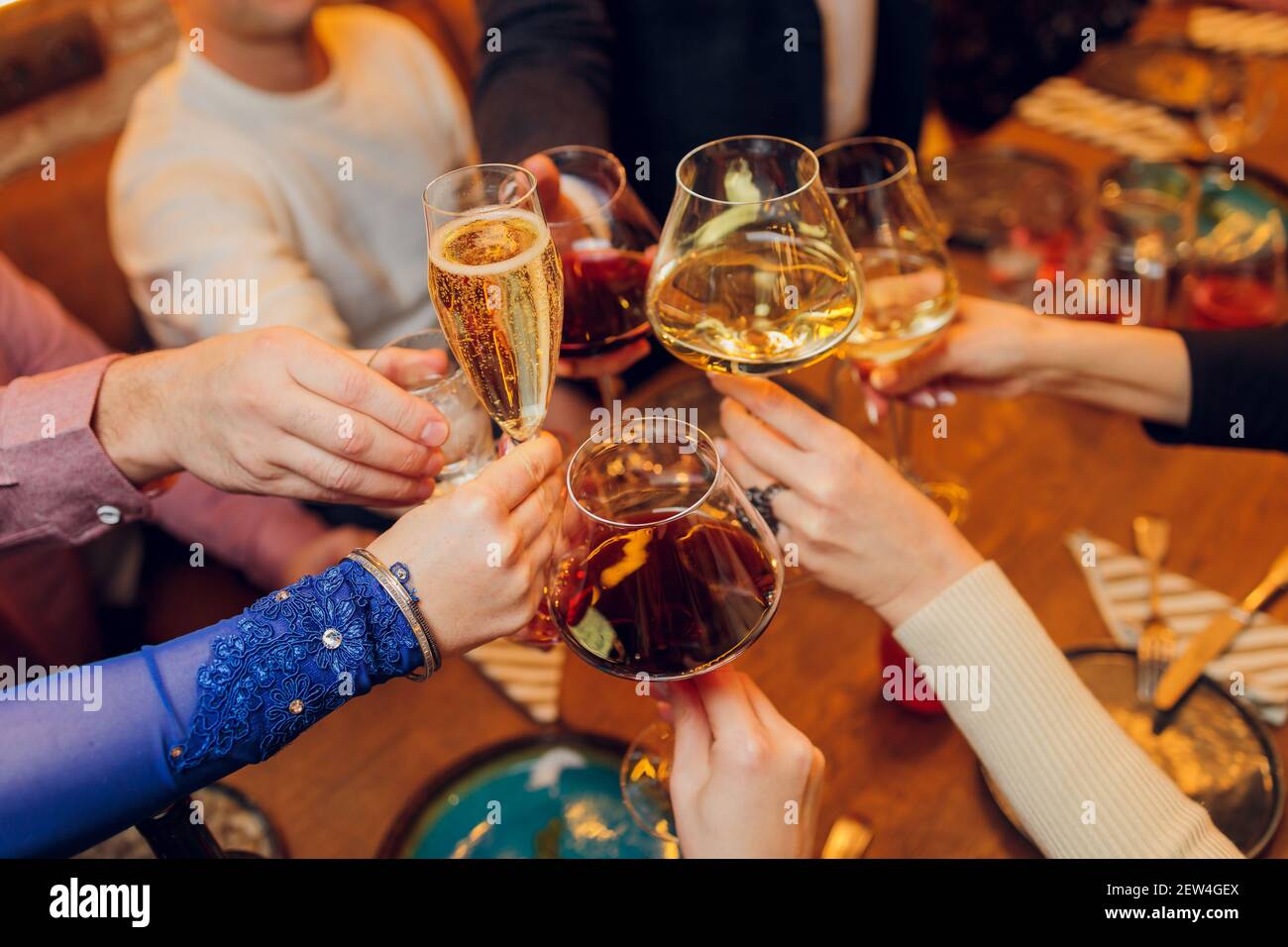 Clinking glasses with alcohol and toasting, party Stock Photo - Alamy