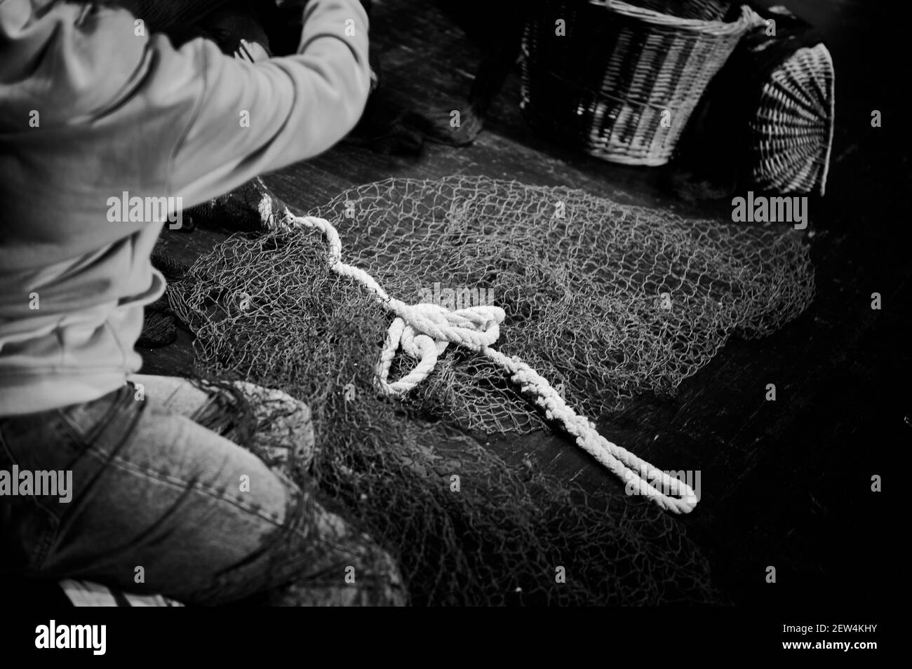 young woman repairing a fishing net Stock Photo - Alamy