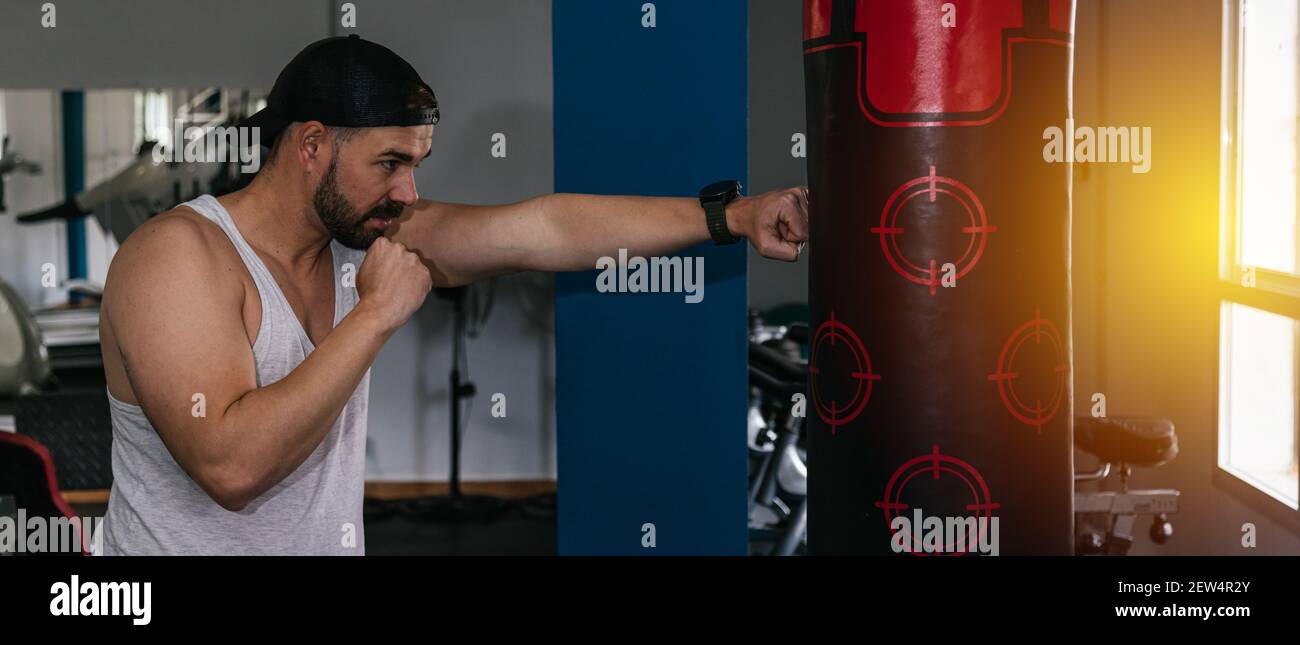 Man punching punching bag in gym. Gym Stock Photo - Alamy