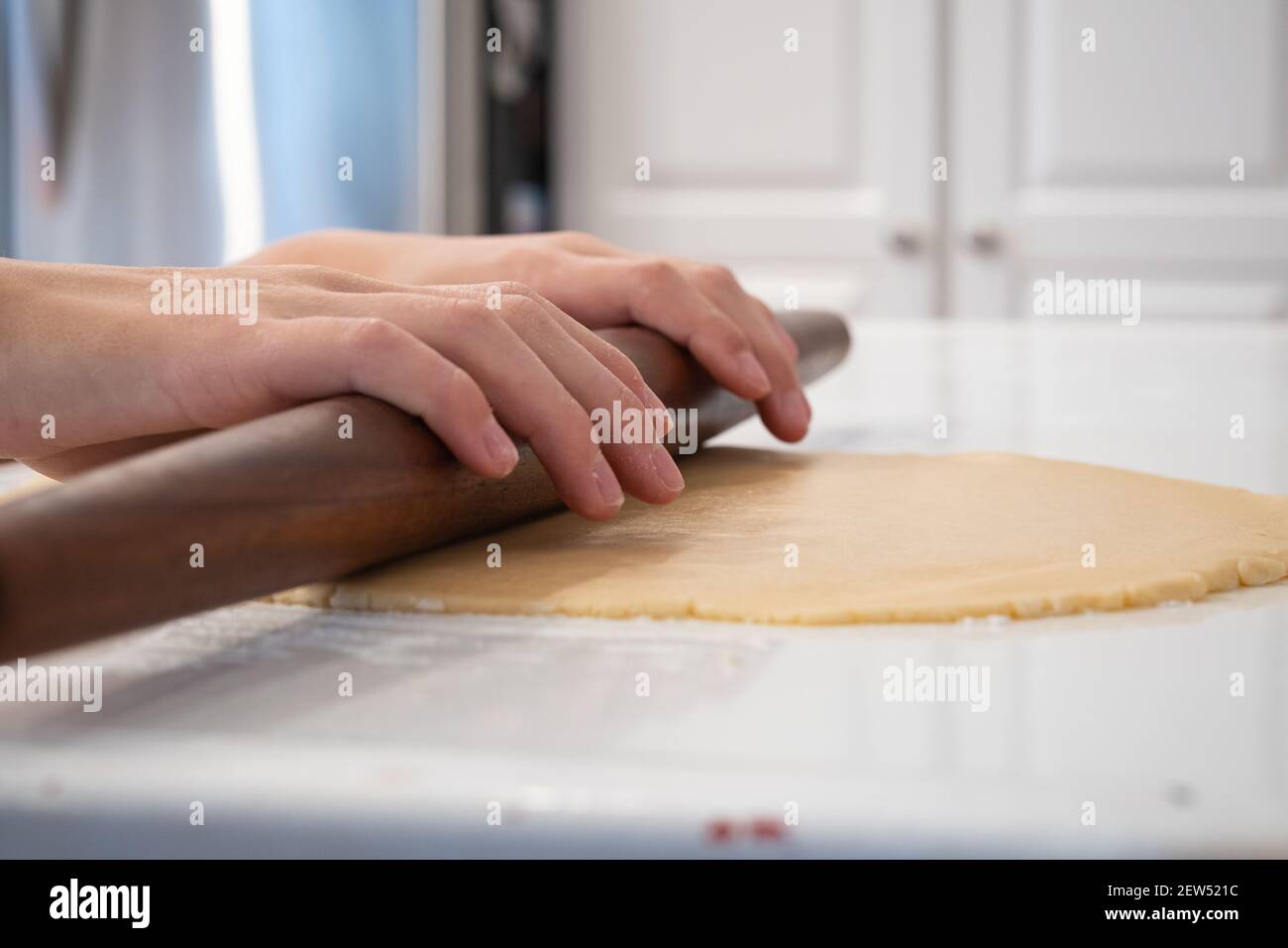 A closeup of a person rolling out dough using a rolling pin Stock Photo ...